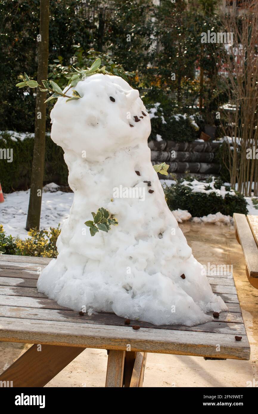 Vertical shot of a snowman on the wooden bench in the park Stock Photo ...
