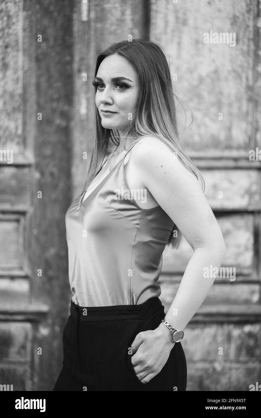 Grayscale of a gorgeous Caucasian female in stylish outfit posing on ...