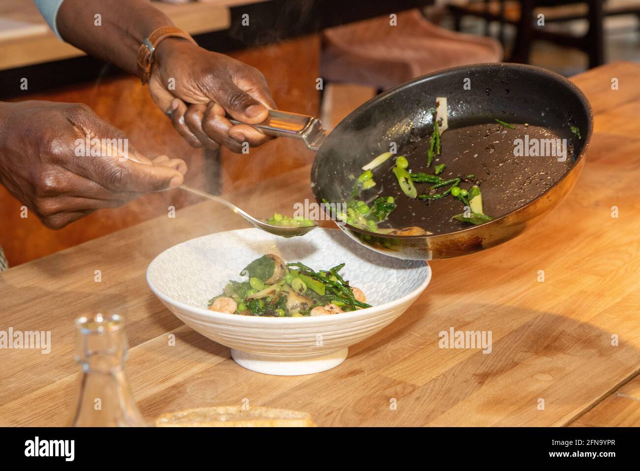 A delicious plate of potatoes fricassee with tiger prawns and green ...