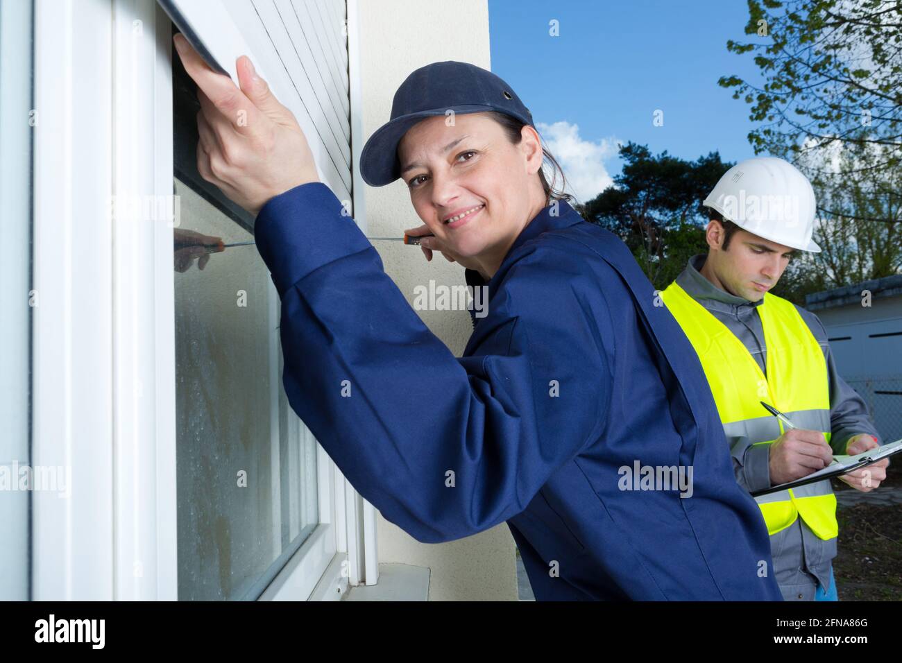 female contractor installing window shutter Stock Photo - Alamy