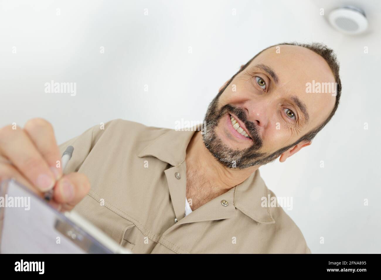 salesman writing on clipboard against white background Stock Photo - Alamy
