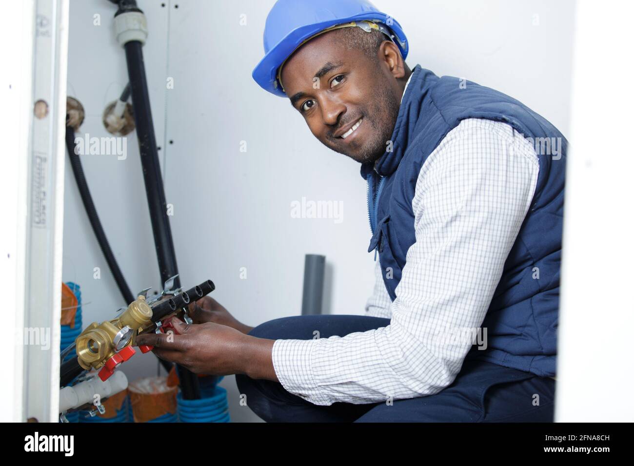 african male plumber fixing sink pipe in kitchen Stock Photo - Alamy