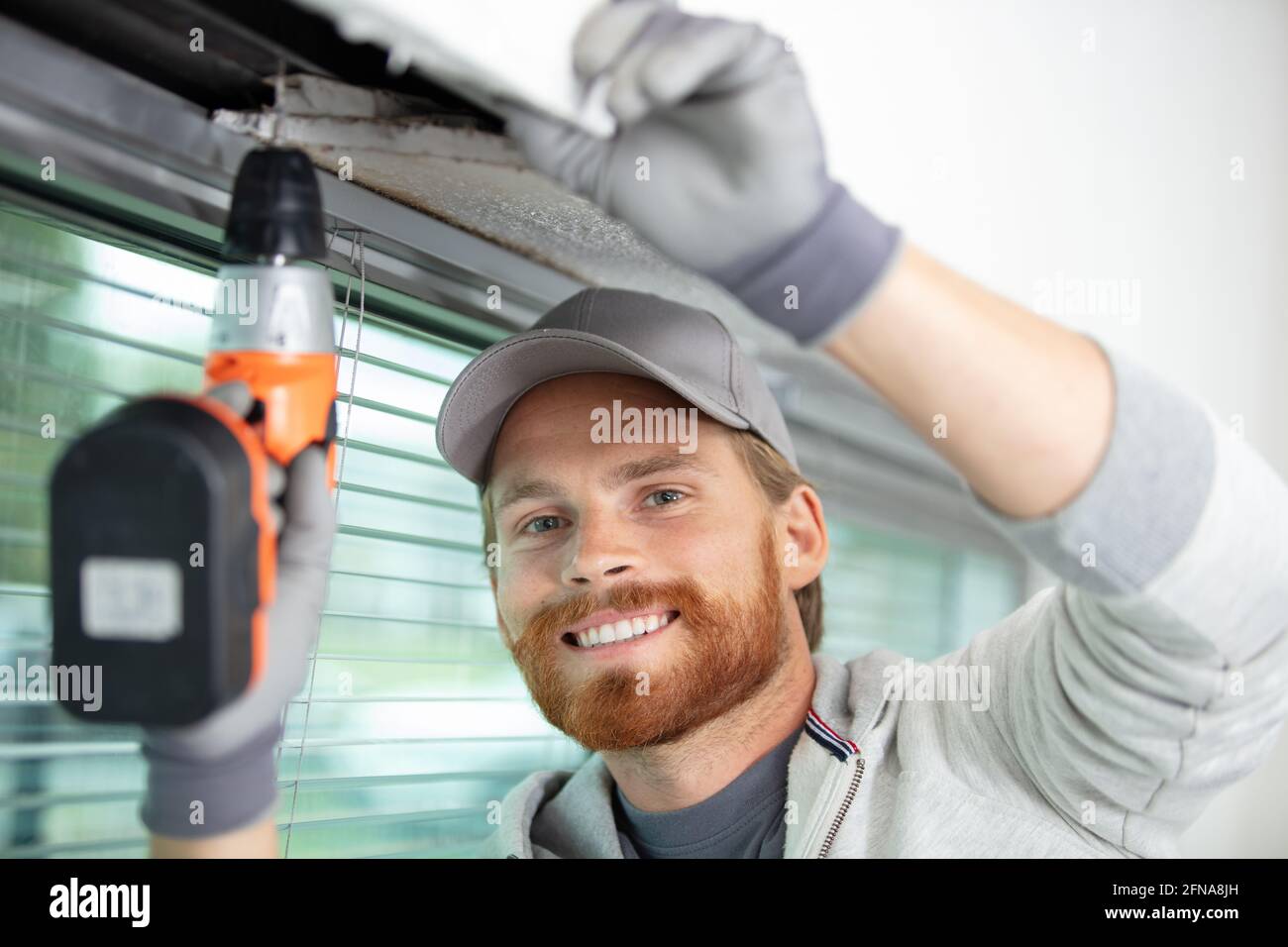 handyman using a cordless screwdriver to install a window Stock Photo ...