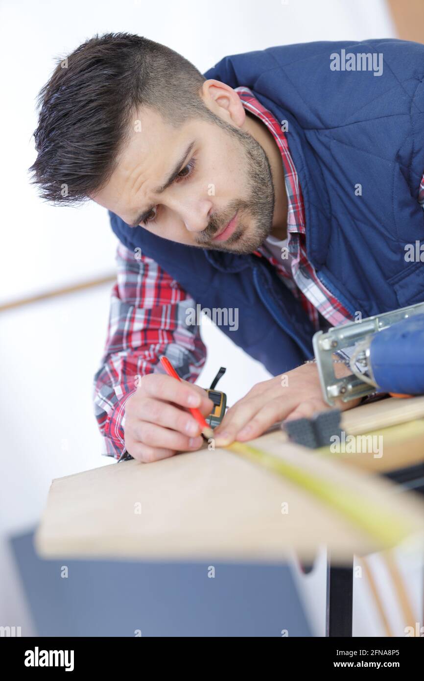 man carpenter in his home studio working with wood Stock Photo - Alamy