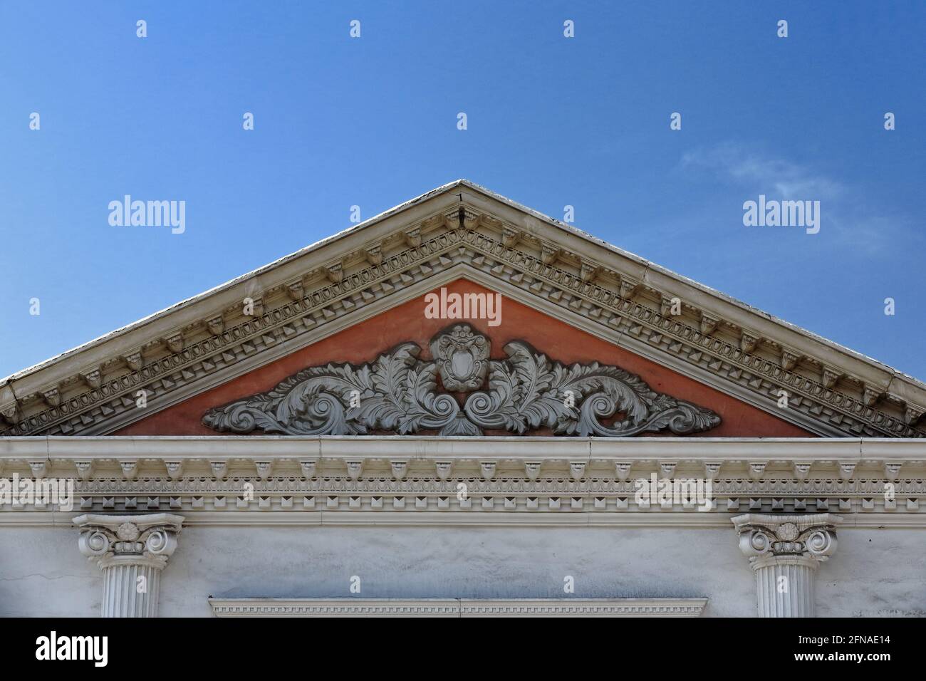 Neoclassical pediment-Ionic columns-relief carving on tympanum-mock Venetian style building ...