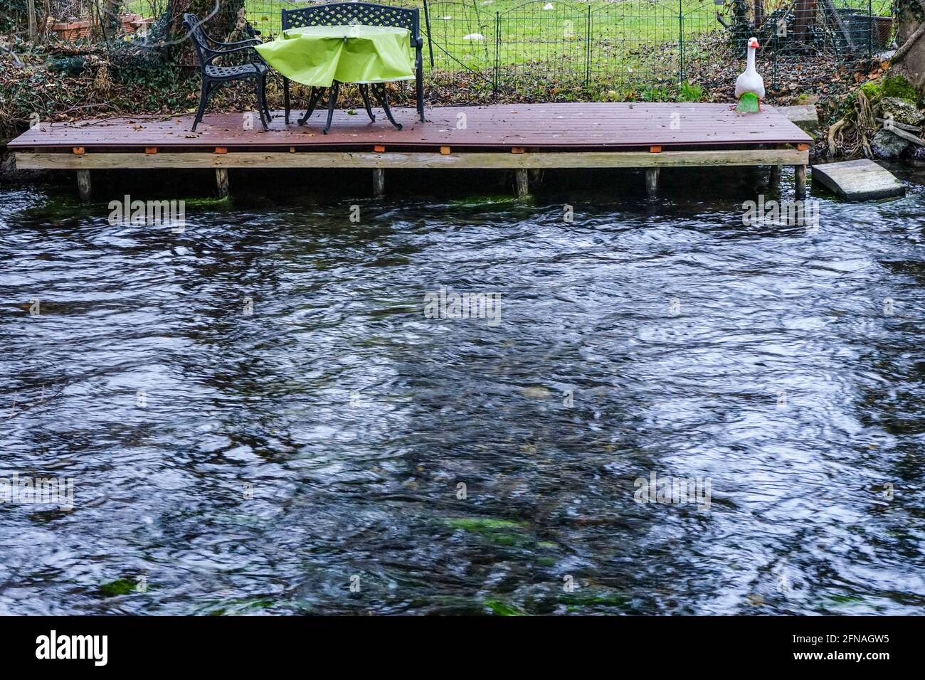 A river with a small private jetty on which local residents have placed ...