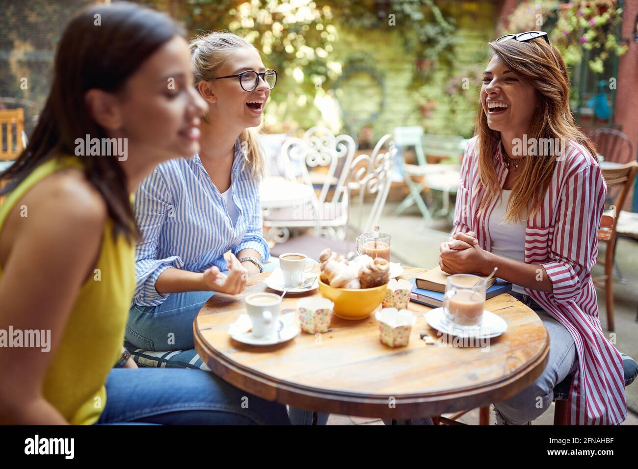 A group of female students is enjoying a chat while having a drink in a ...