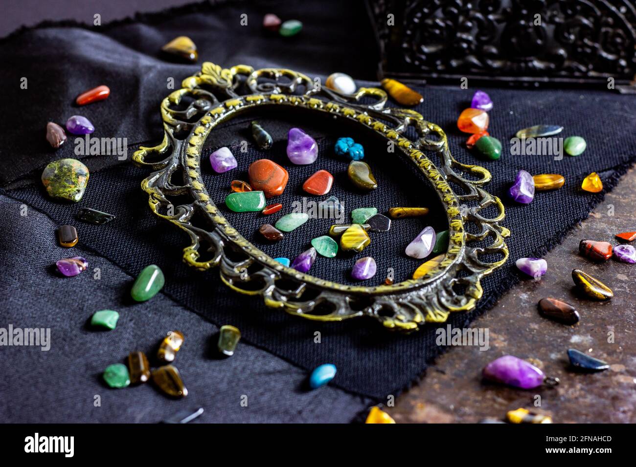 Different colorful gemstones in a frame on dark background. Stone ...