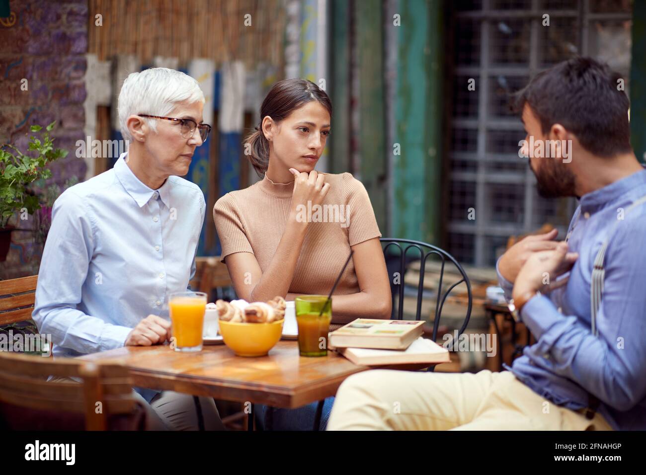 Two female friends of different generations accusing their young male ...