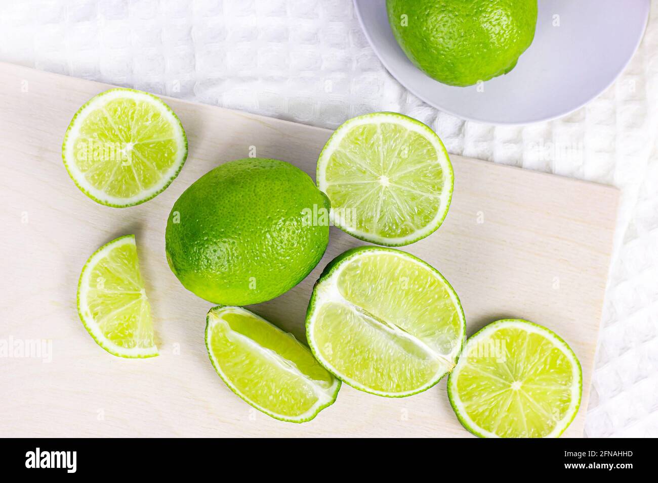 Top view of fresh green juicy limes and lime slices in the kitchen on ...