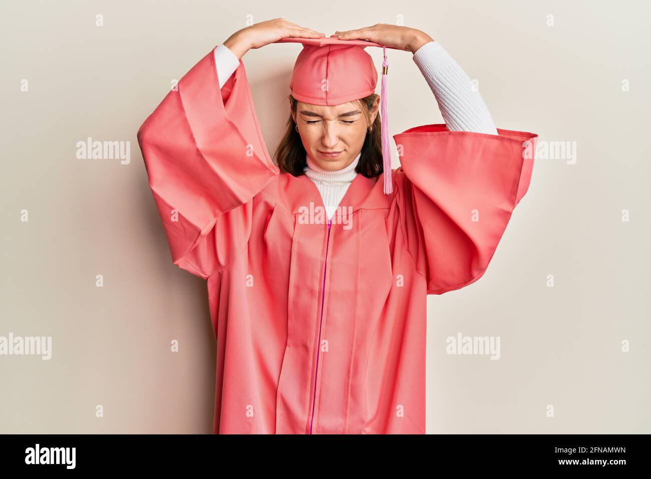 Young caucasian woman wearing graduation cap and ceremony robe ...