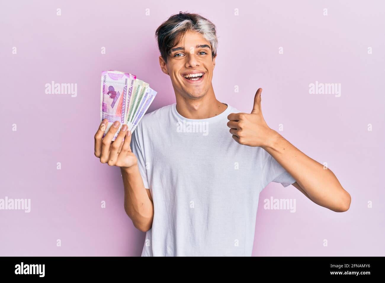 Young hispanic man holding indian rupee banknotes smiling happy and ...