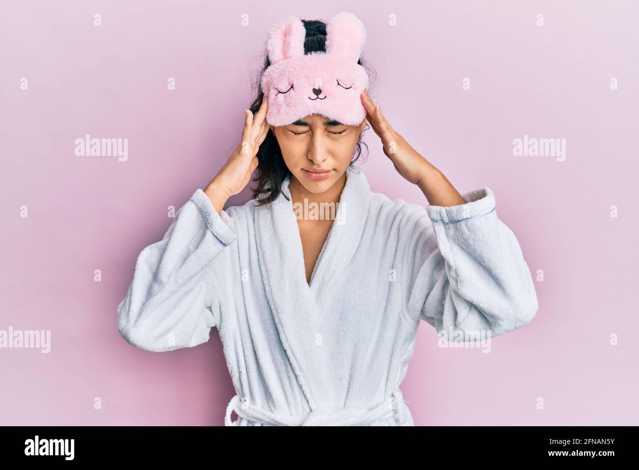 Hispanic teenager girl with dental braces wearing sleep mask and robe ...
