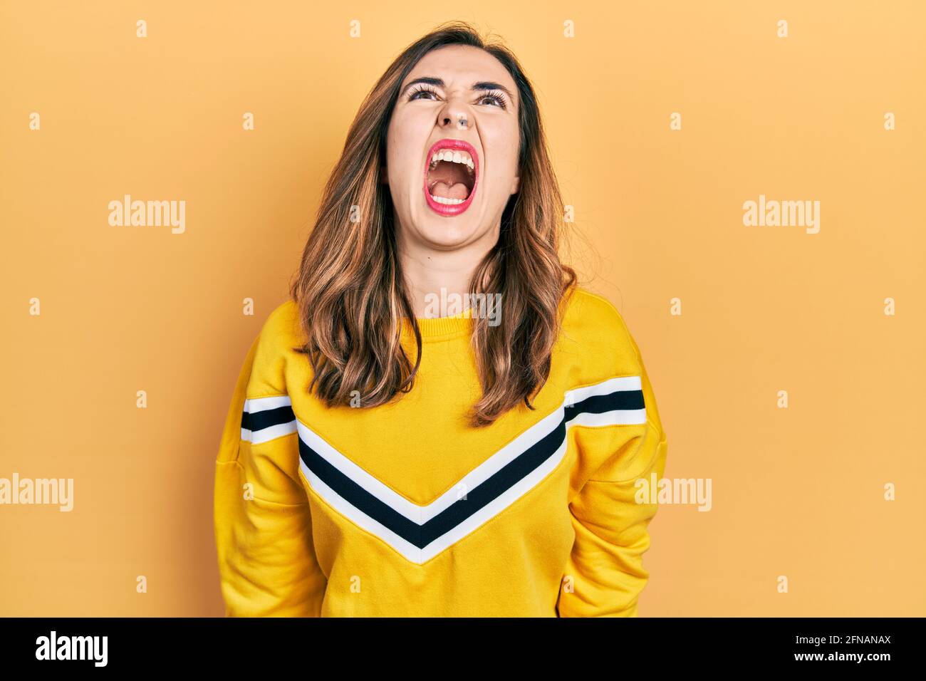 Young hispanic girl wearing casual clothes angry and mad screaming ...