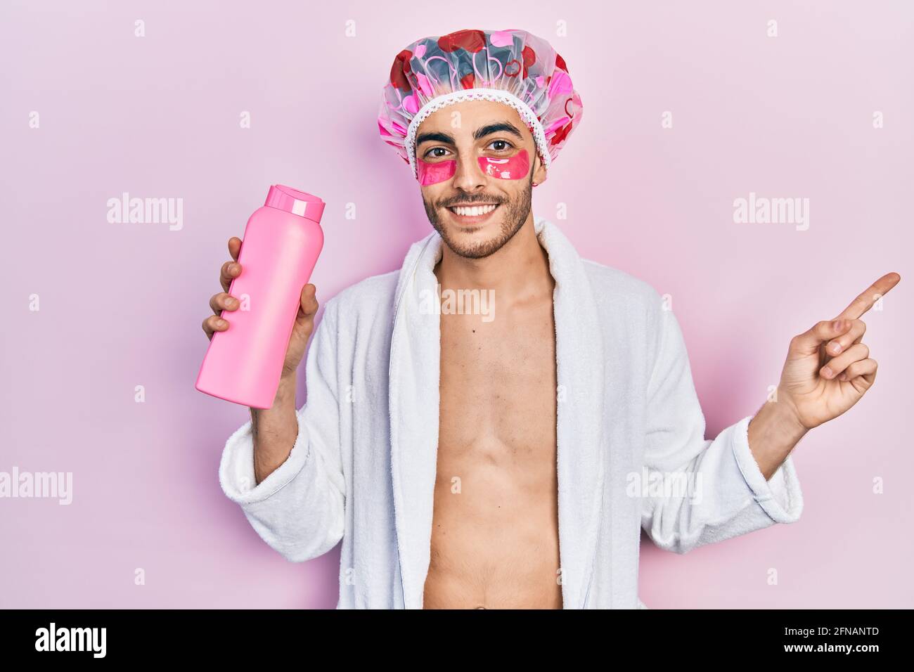 Young hispanic man wearing bathrobe and eye bags patches holding ...