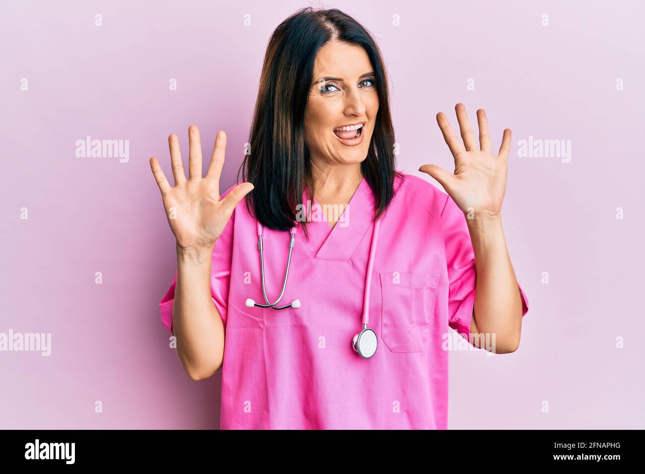 Middle age brunette woman wearing doctor uniform and stethoscope ...
