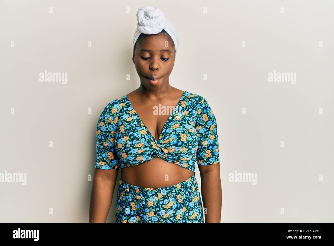 Young african woman wearing hair turban and african style making fish ...