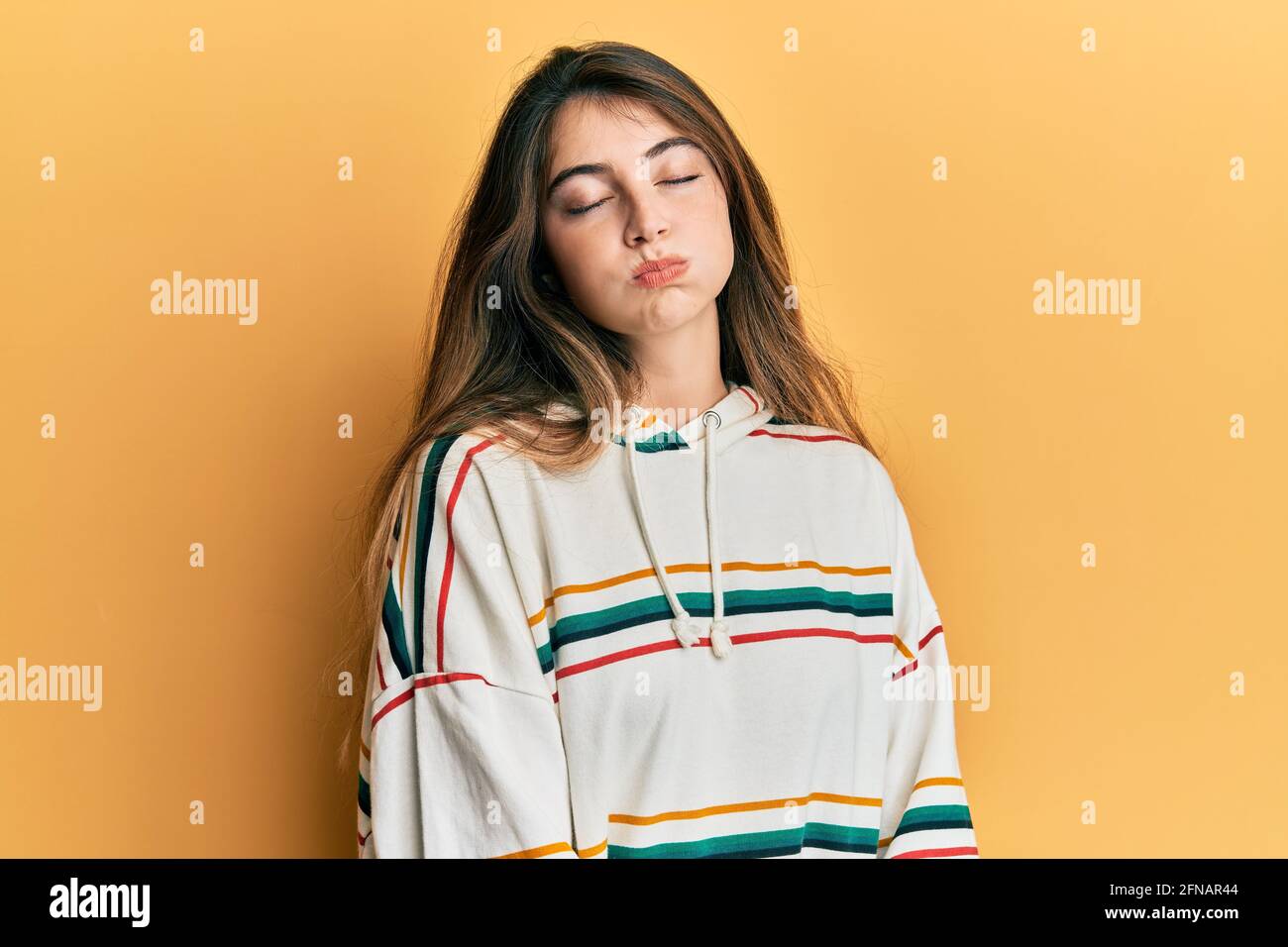 Young caucasian woman wearing casual clothes puffing cheeks with funny ...