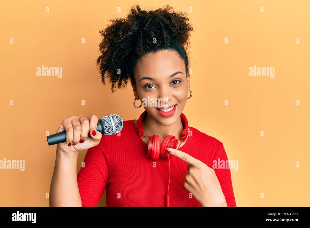 Young african american girl singing song using microphone and ...