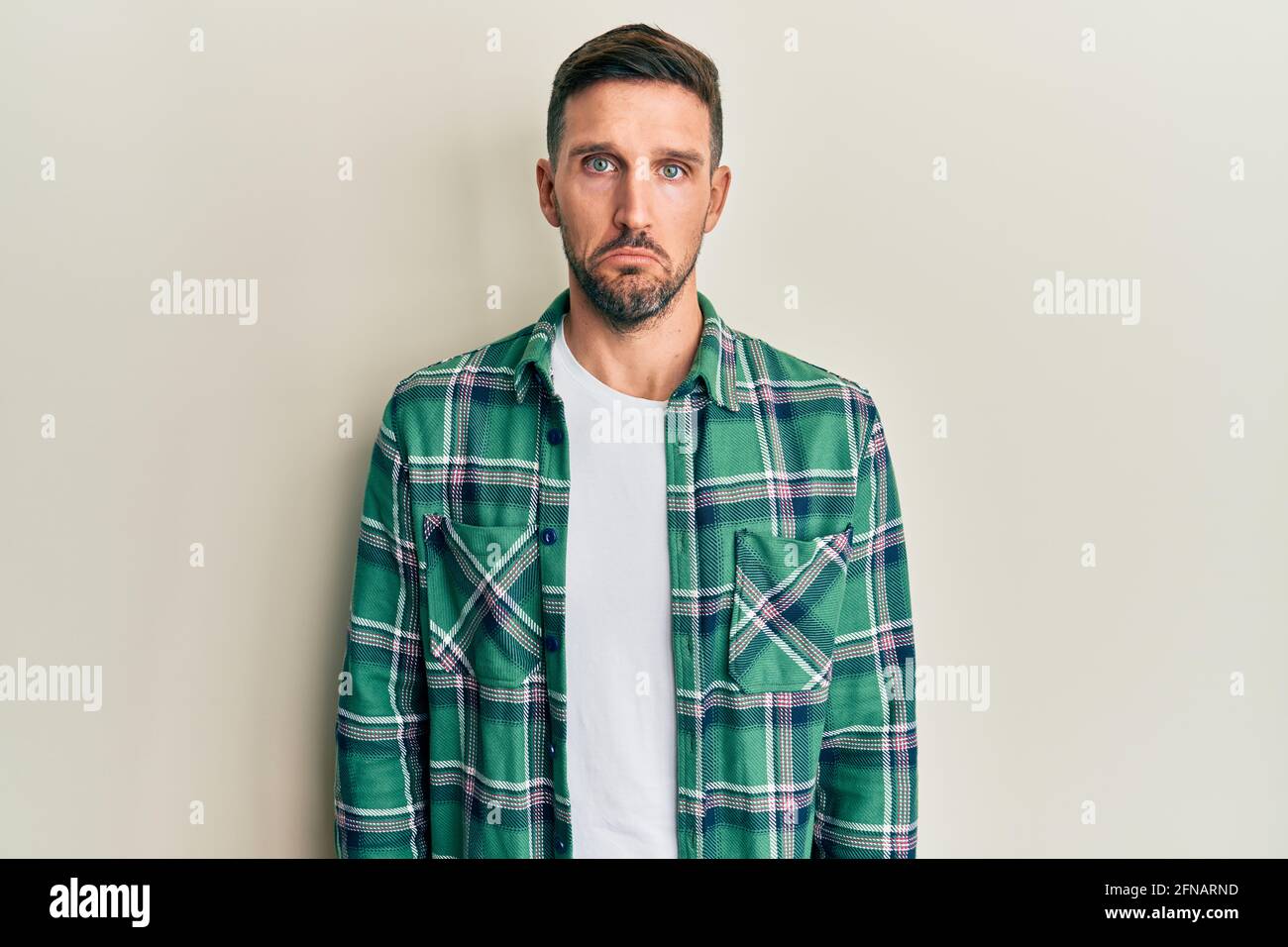 Handsome man with beard wearing casual clothes depressed and worry for ...