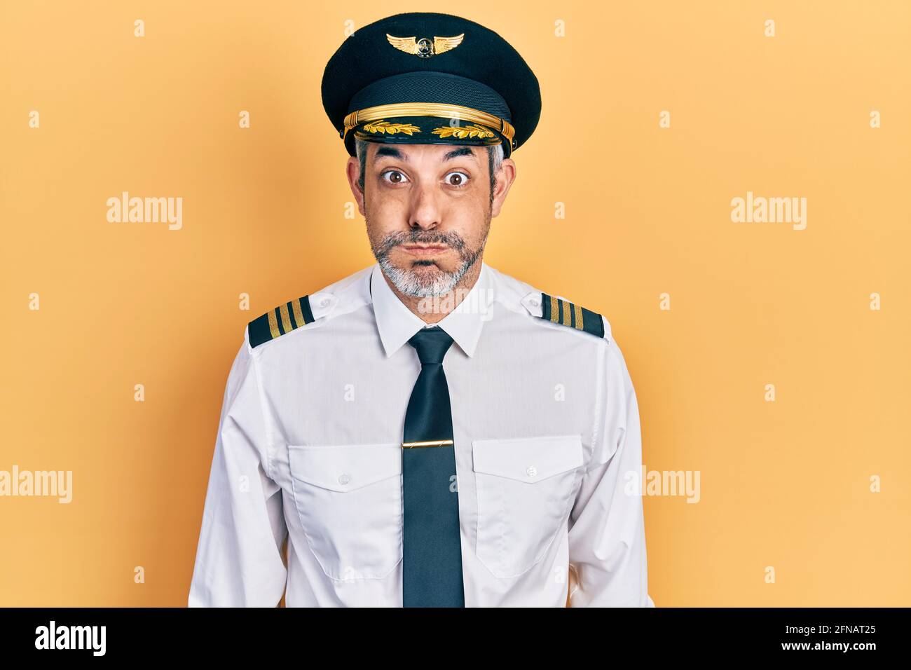 Handsome middle age man with grey hair wearing airplane pilot uniform ...