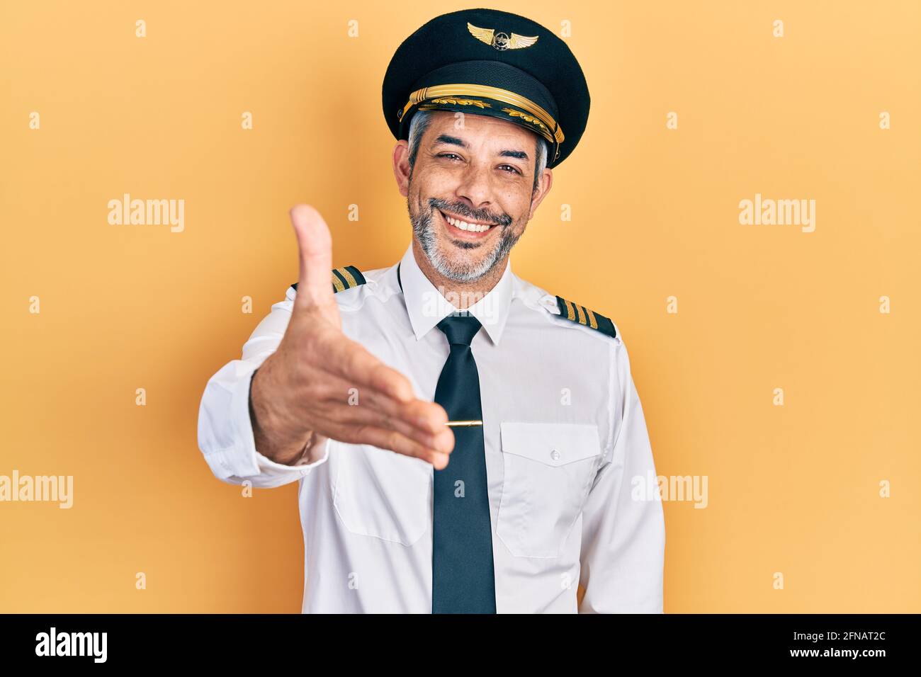 Handsome middle age man with grey hair wearing airplane pilot uniform ...