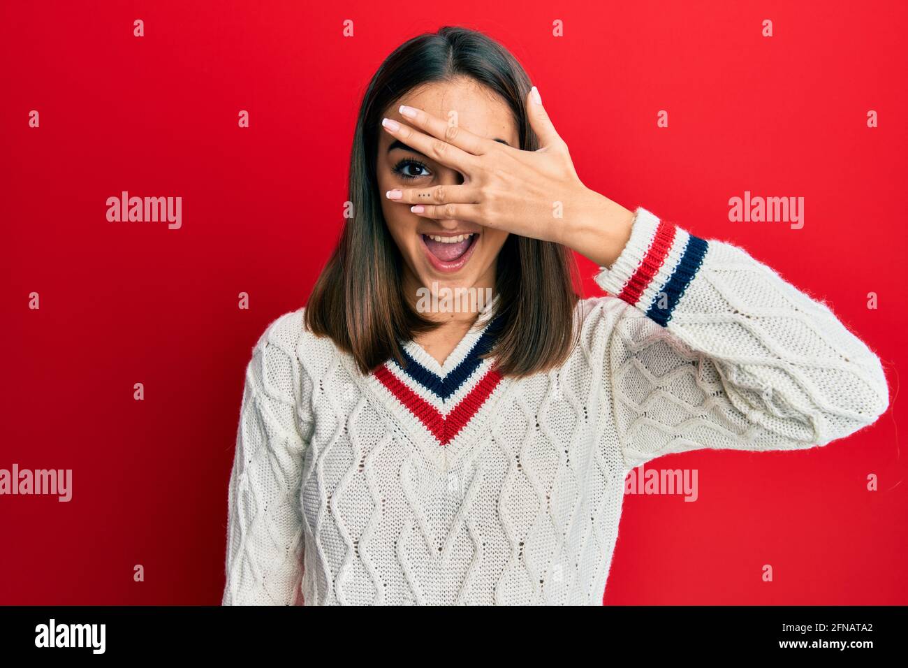 Young brunette girl wearing casual student sweater peeking in shock ...