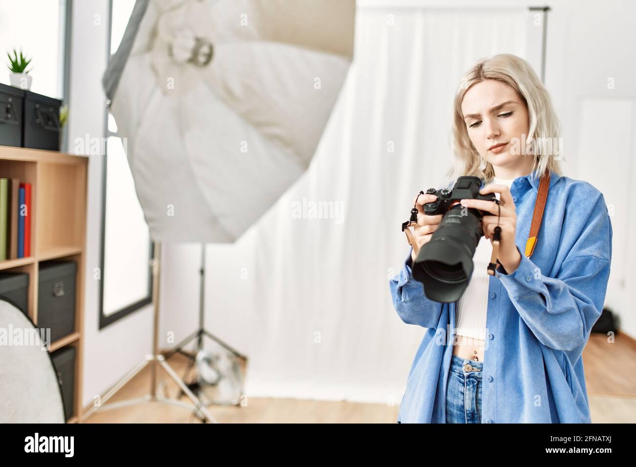 Beautiful blonde woman working as professional photographer at ...