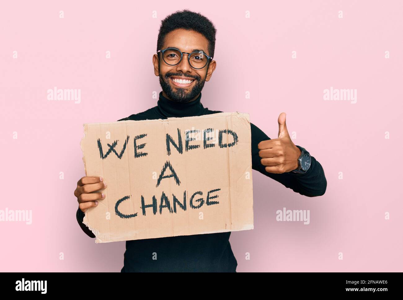 Young african american man holding we need a change banner smiling ...