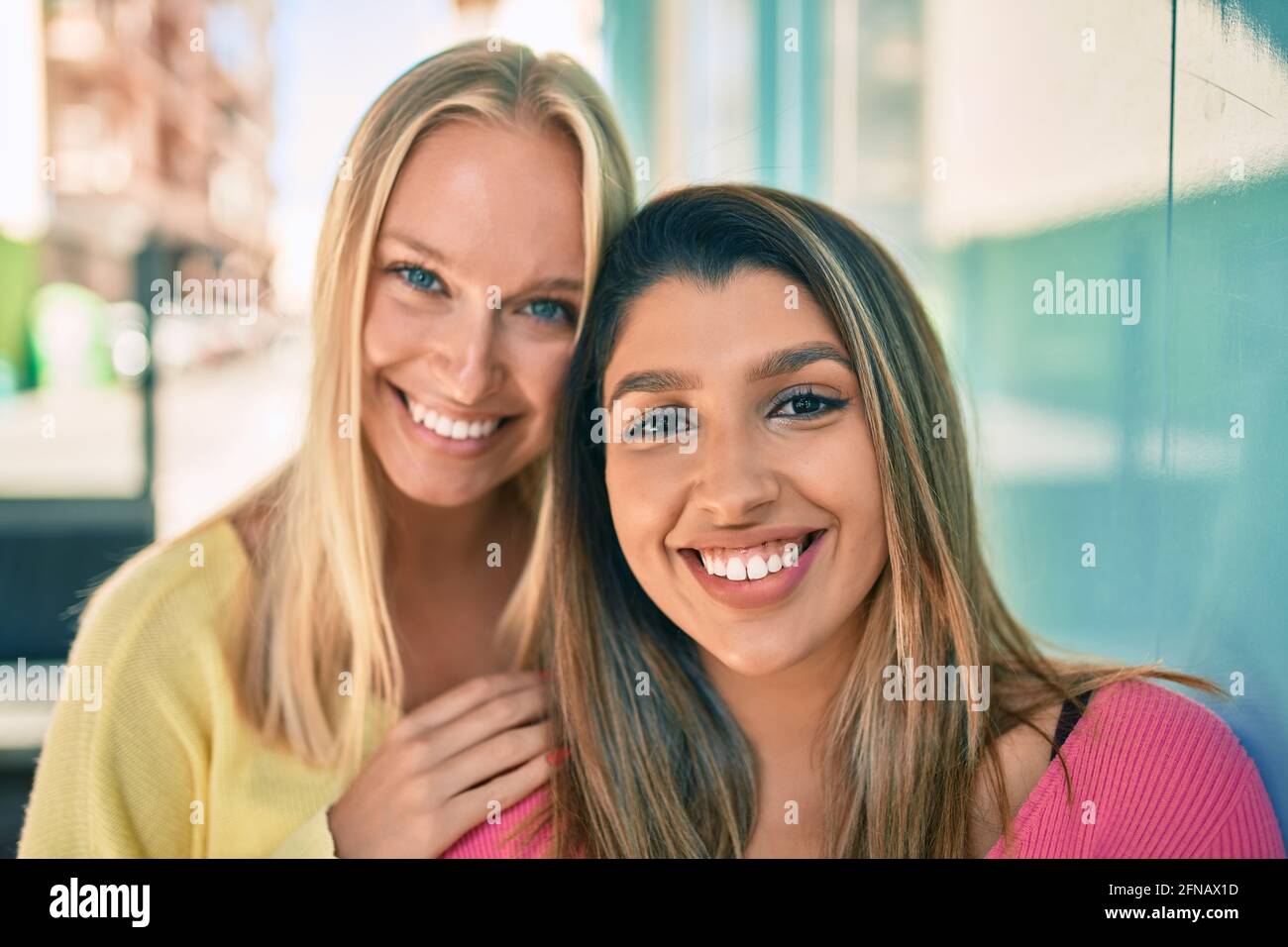 Two beautiful and young girl friends together having fun at the city ...