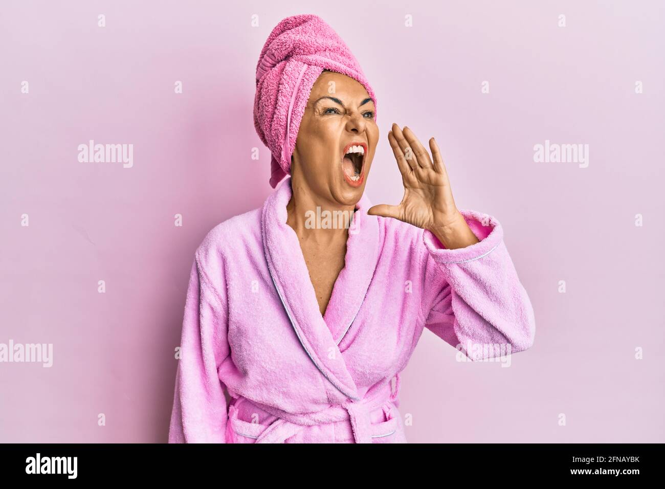Middle age hispanic woman wearing shower towel cap and bathrobe ...
