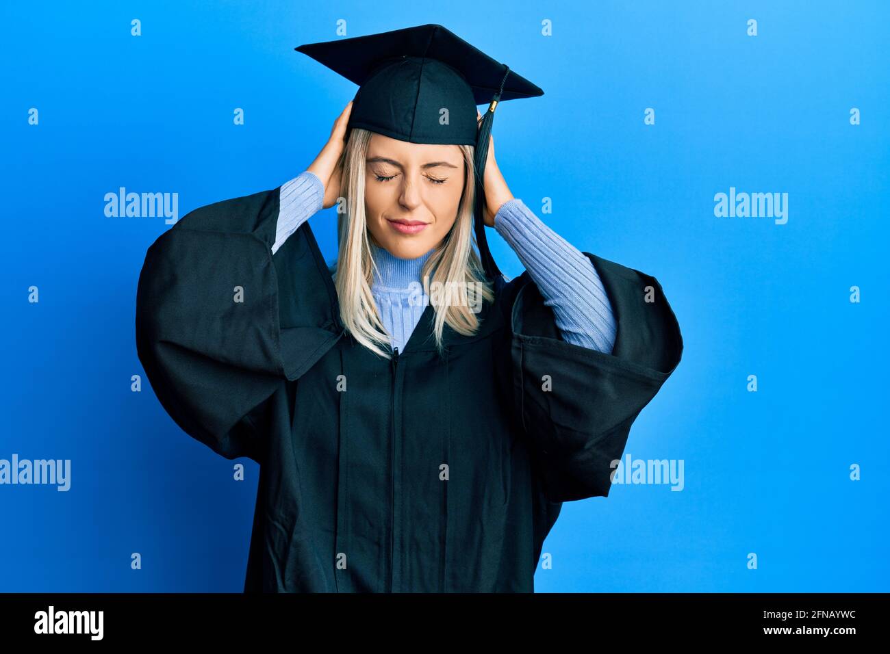 Beautiful blonde woman wearing graduation cap and ceremony robe ...