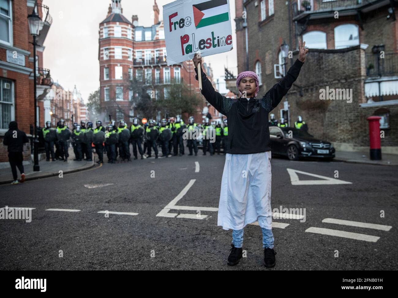 London, UK. 15th May, 2021. A man holding place card in front of police ...