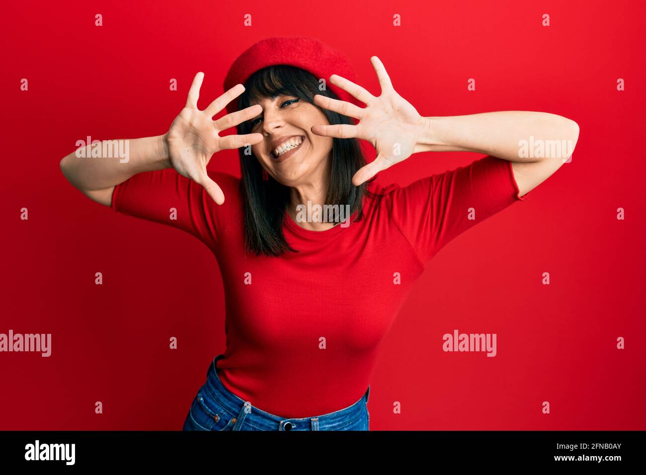 Young hispanic woman wearing french look with beret showing and ...