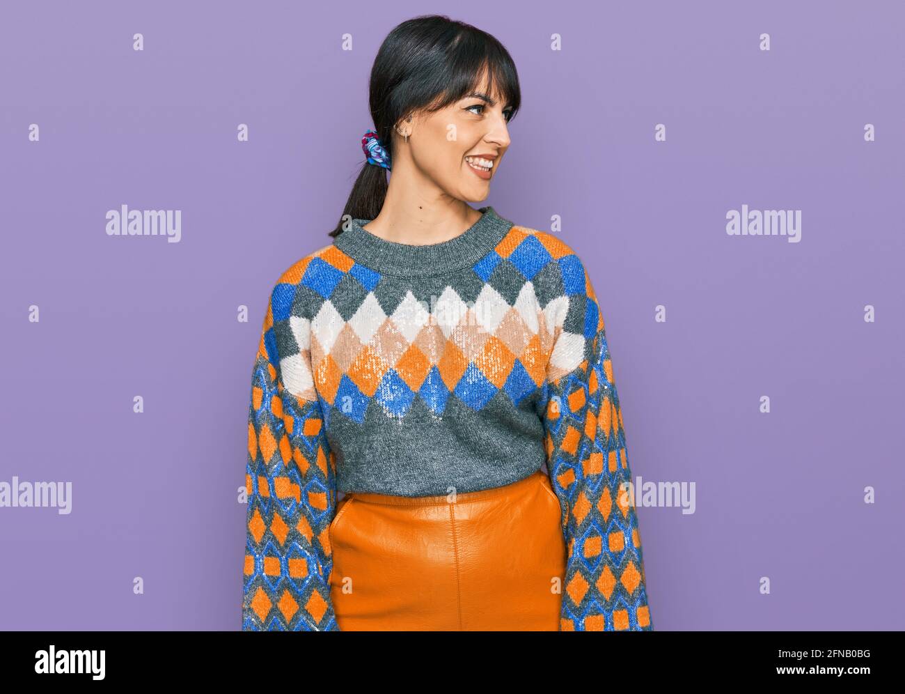 Young hispanic woman wearing casual clothes looking away to side with ...