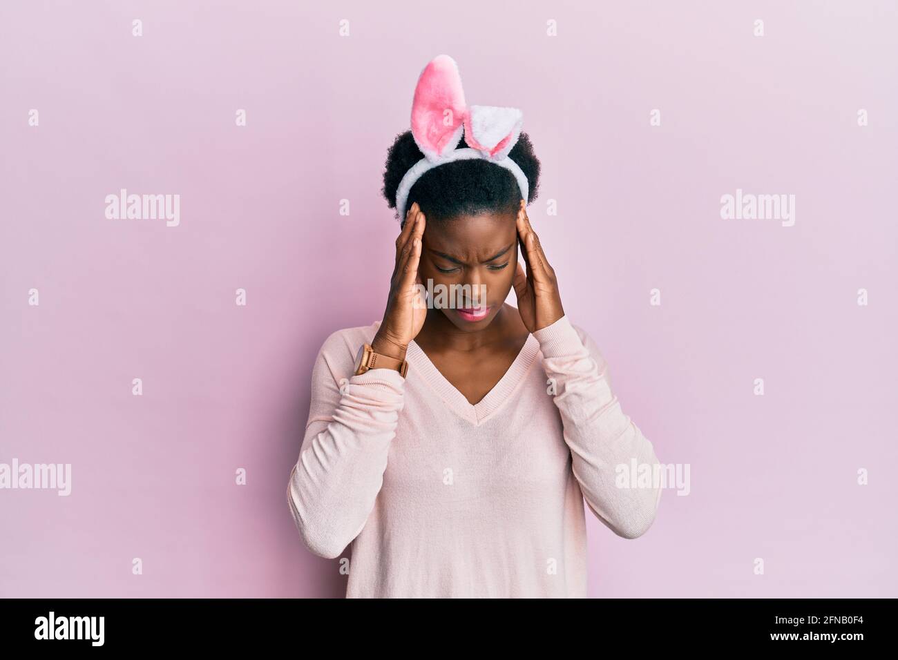 Young african american girl wearing cute easter bunny ears with hand on ...