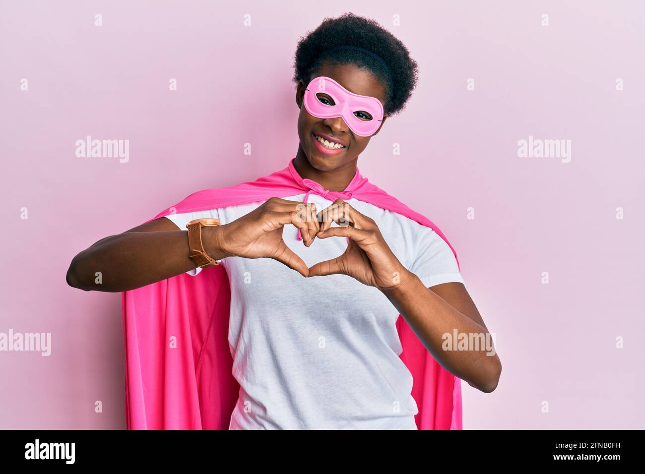 Young african american girl wearing superhero mask and cape costume ...