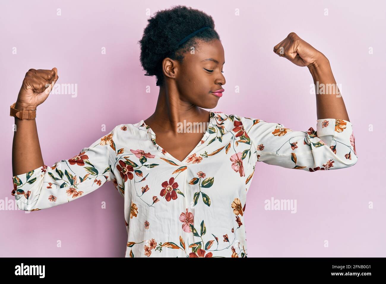 Young african american girl wearing casual clothes showing arms muscles ...