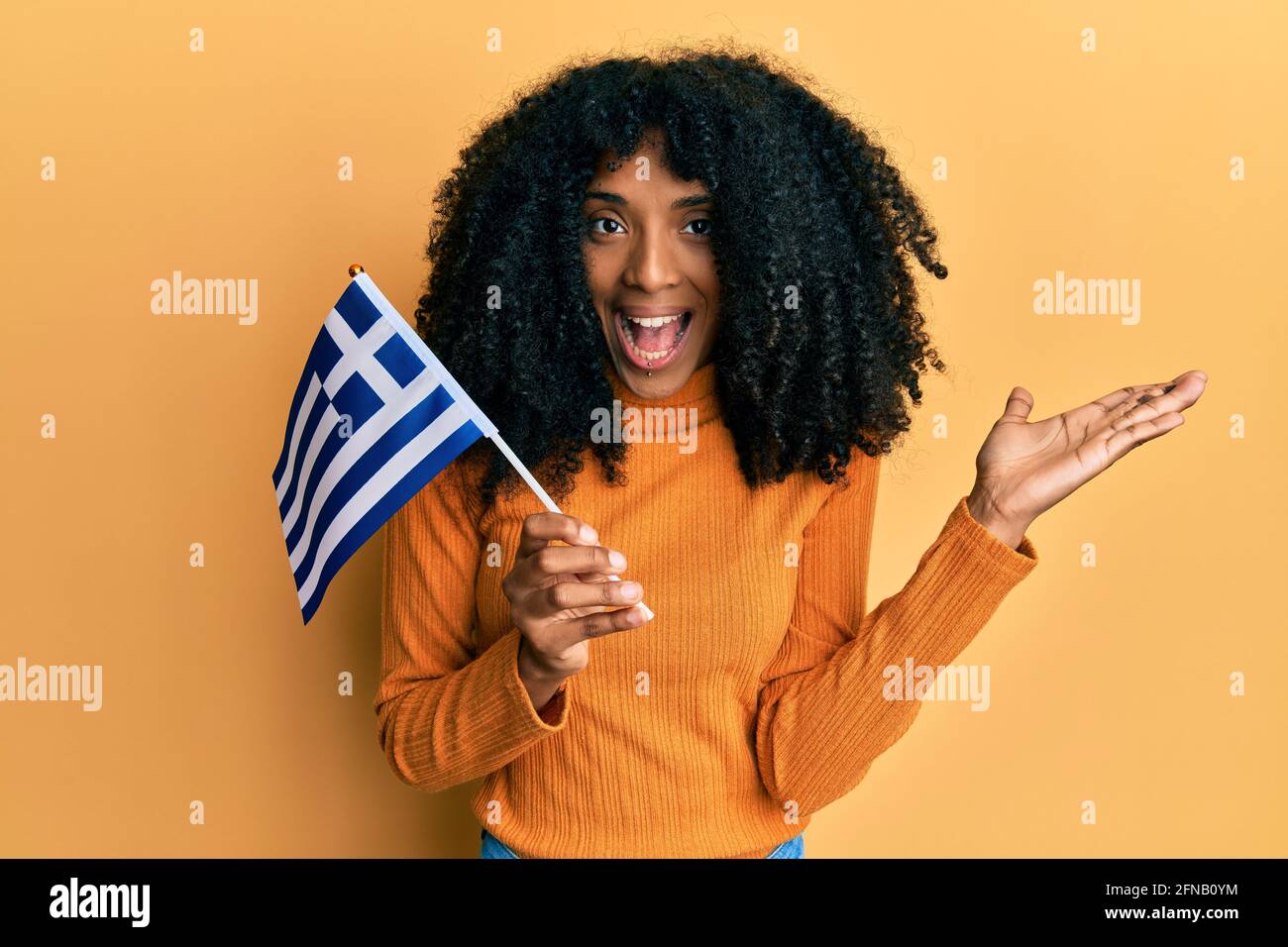 African american woman with afro hair holding greece flag celebrating ...