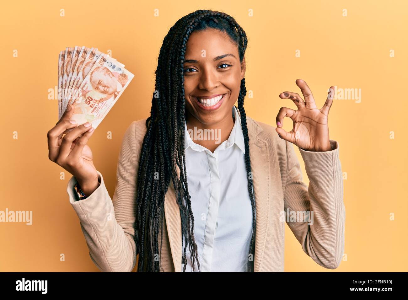 African american woman with braids holding 50 turkish lira banknotes ...