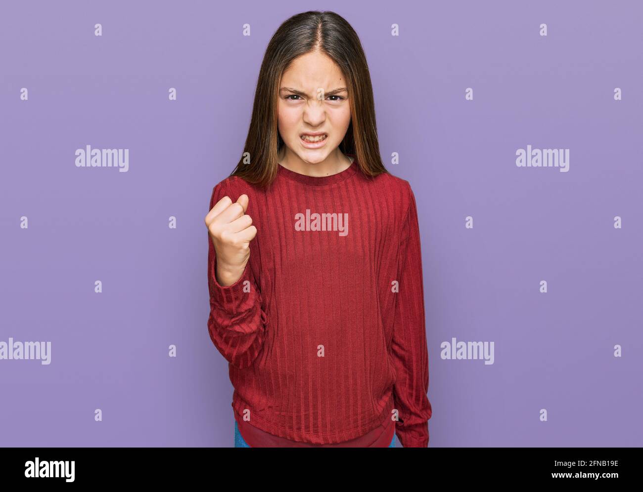 Beautiful brunette little girl wearing casual sweater angry and mad ...