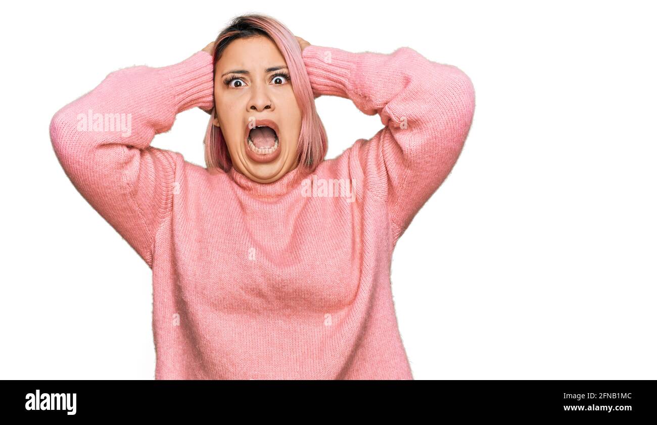 Hispanic woman with pink hair wearing casual winter sweater crazy and ...