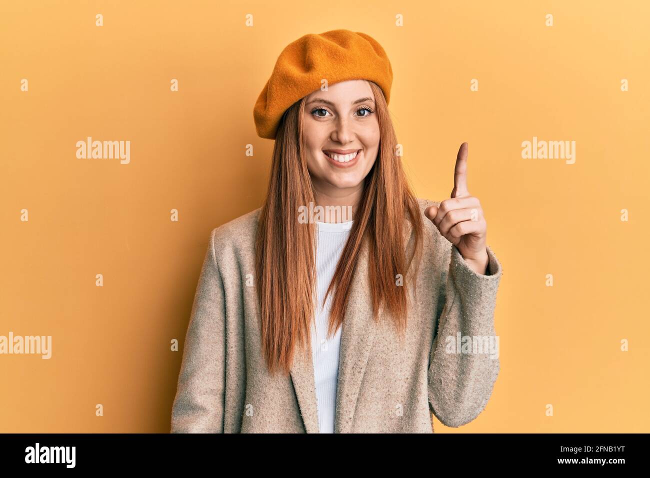 Young irish woman wearing french look with beret pointing finger up ...
