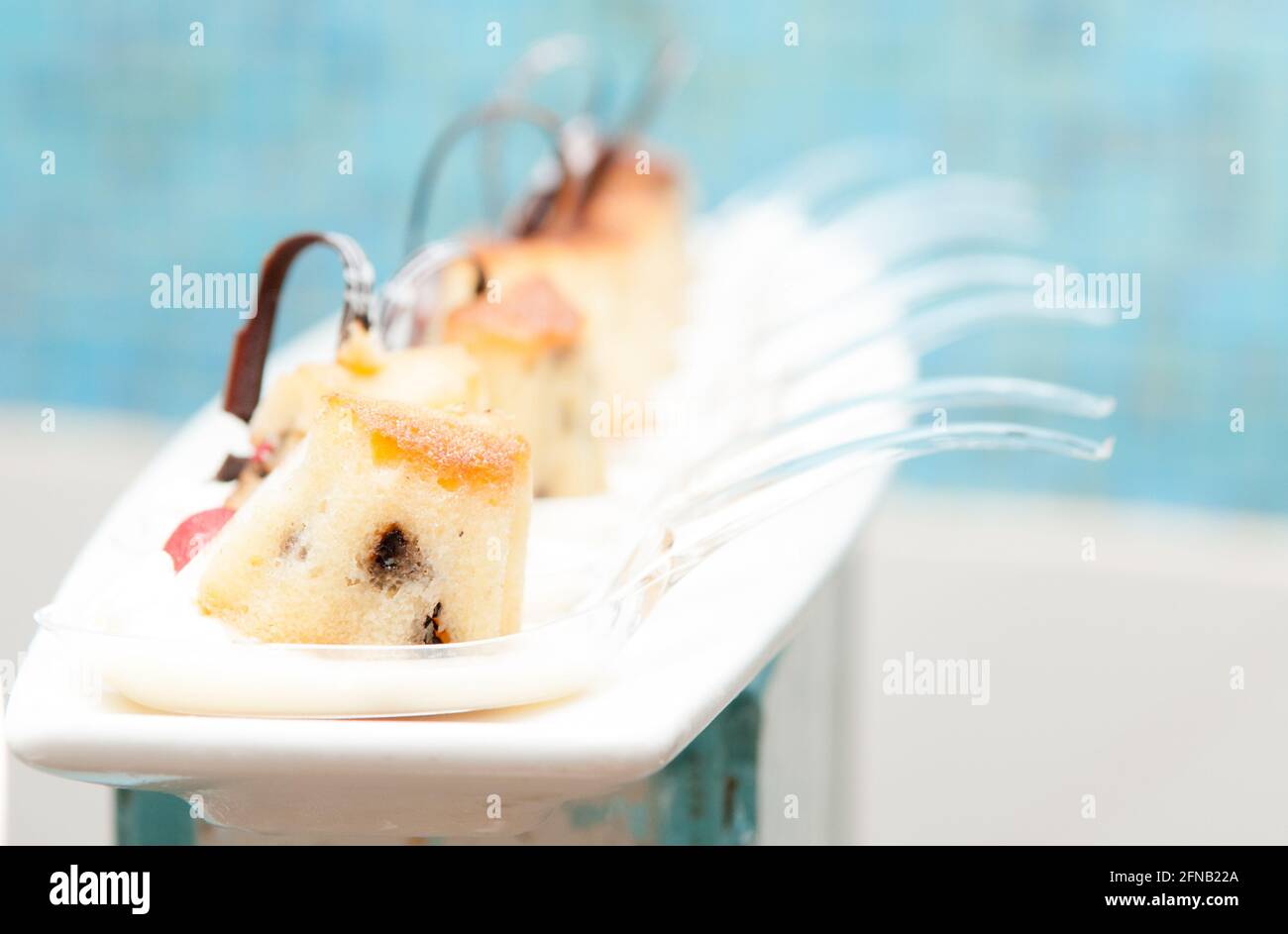 A closeup shot of delicious small cakes put on plastic spoons on a ...