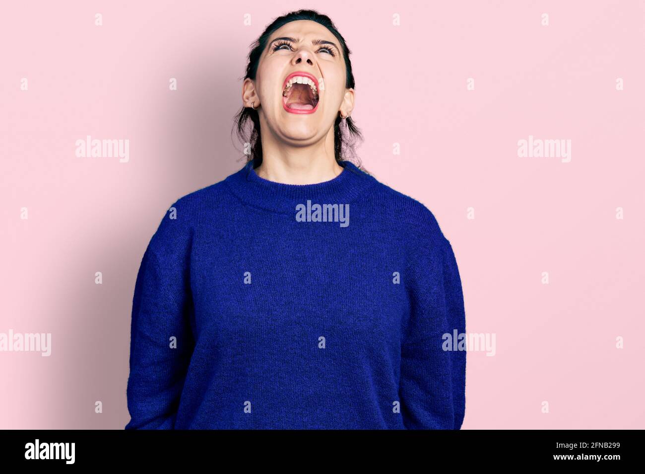 Young hispanic woman wearing casual clothes angry and mad screaming ...