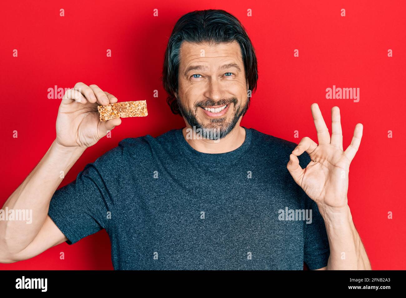 Middle age caucasian man eating protein bar as healthy energy snack ...