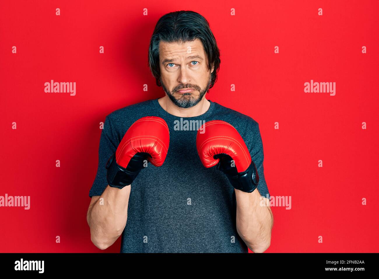 Middle age caucasian man using boxing gloves depressed and worry for ...