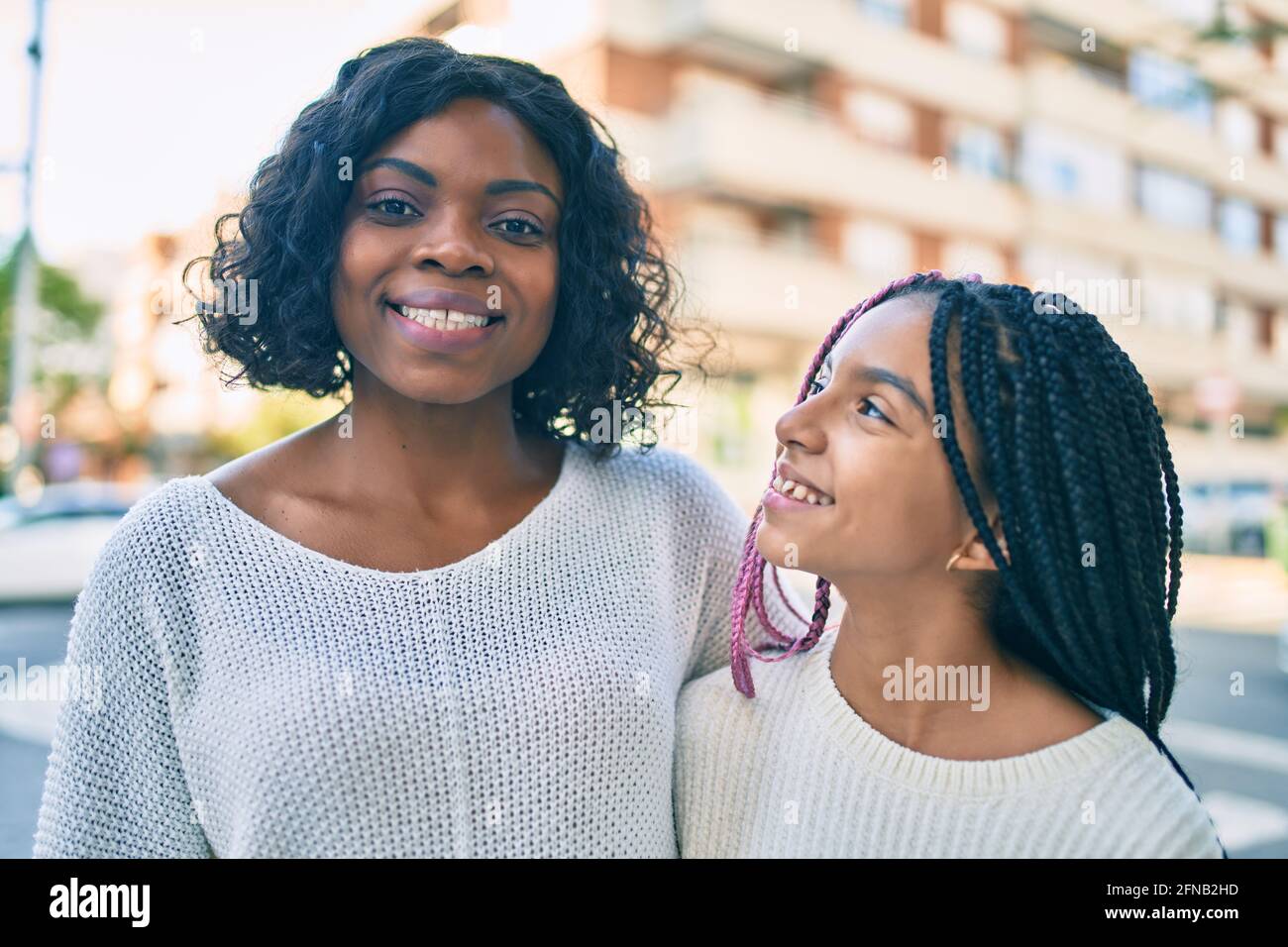 Beautiful african american mother and daughter smiling happy and hugging. Standing with smile on ...