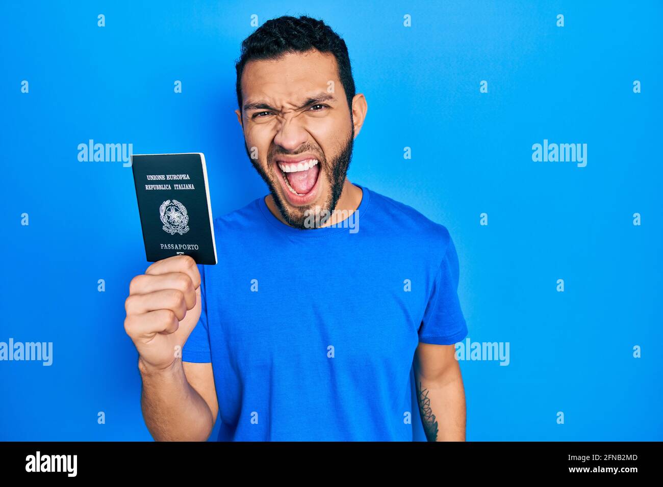 Hispanic man with beard holding italy passport angry and mad screaming ...