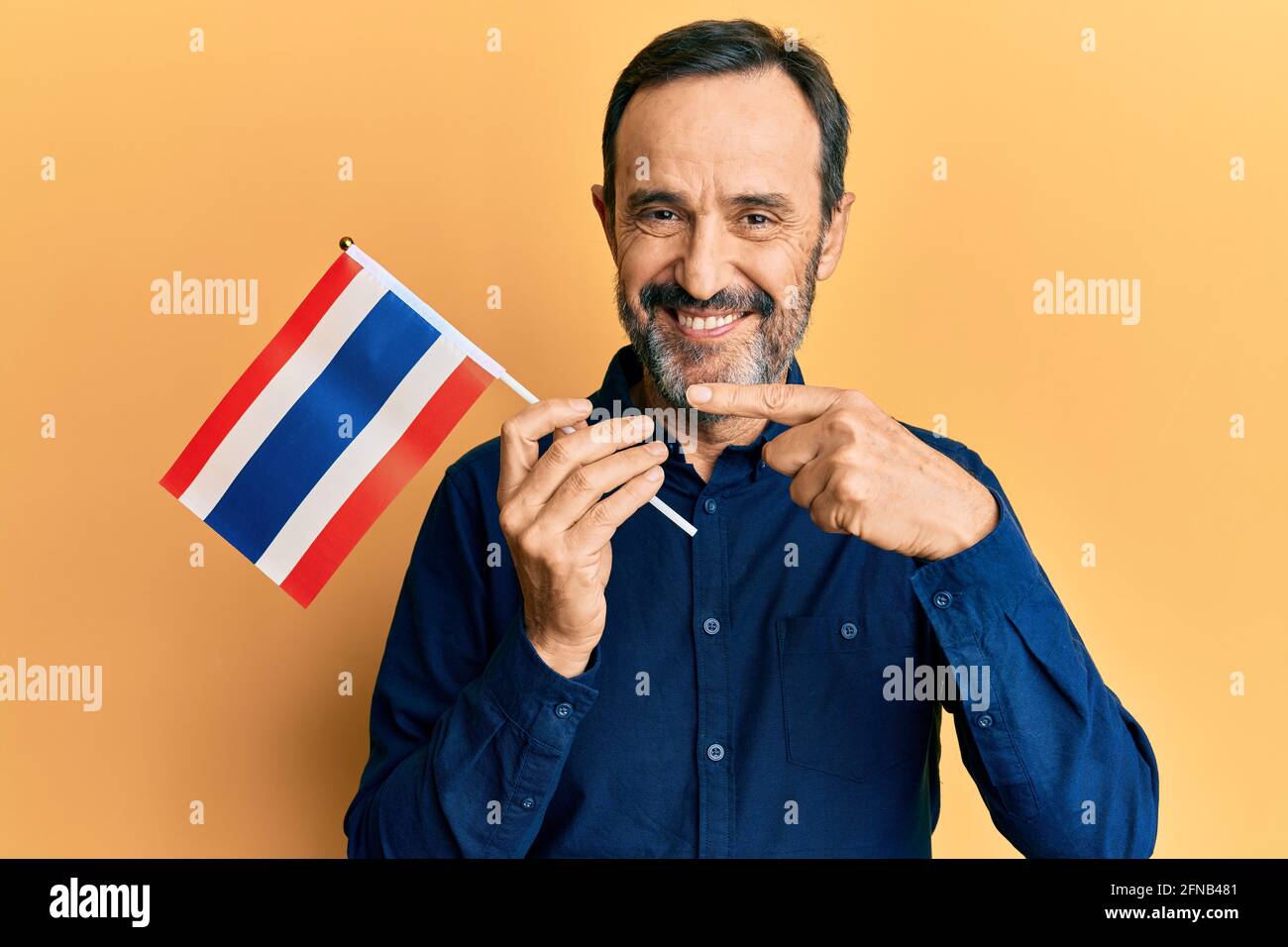 Middle age hispanic man holding philippines flag smiling happy pointing ...
